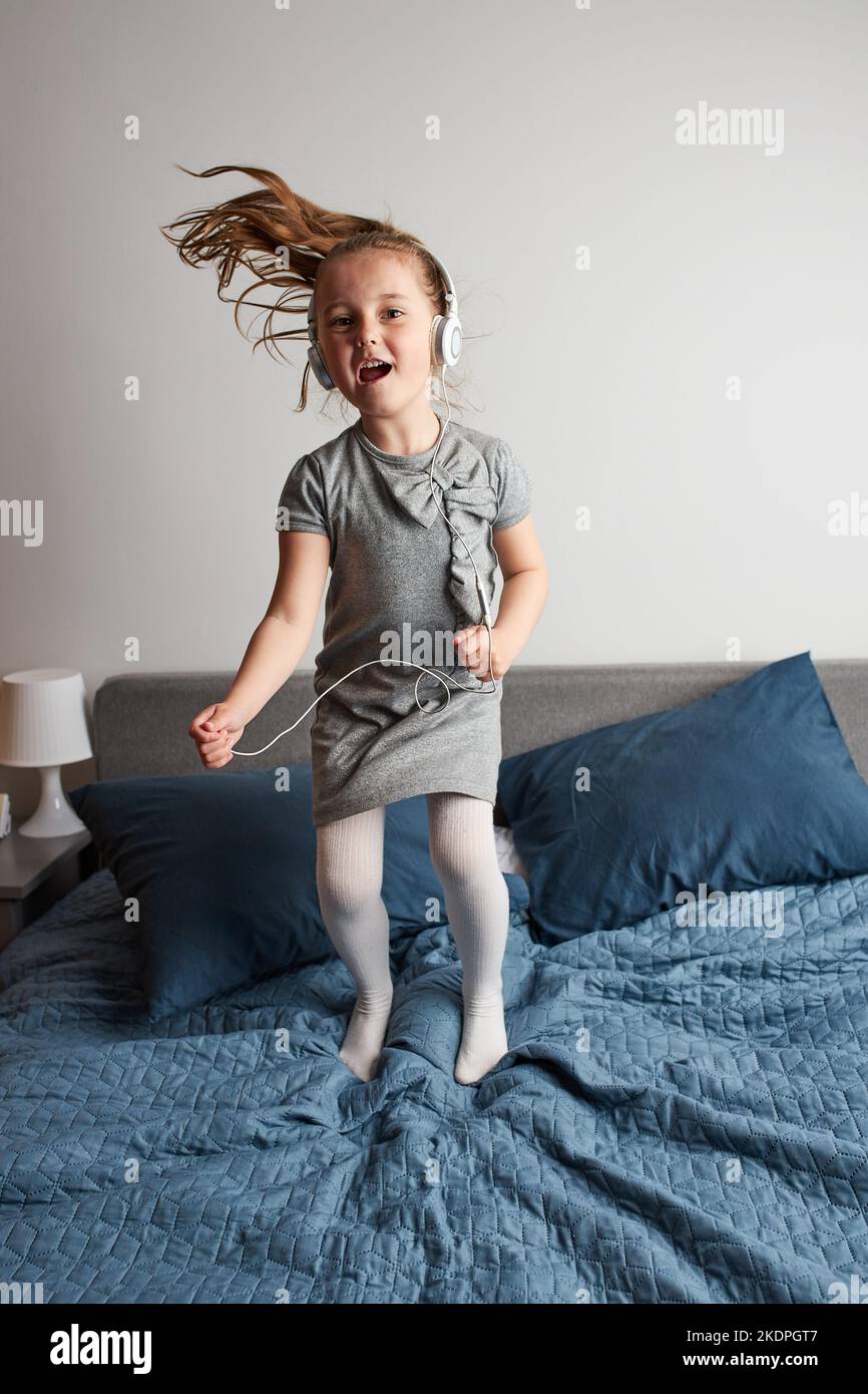 Little girl singing holding headphones cord imitating herself a real ...