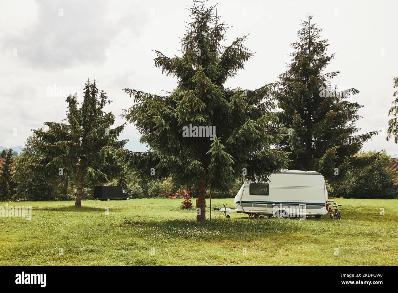 Caravan left among the pine trees on campsite. Copy space top and ...