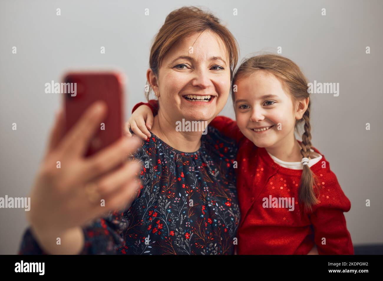 Mother with her little daughter making video call using mobile phone ...