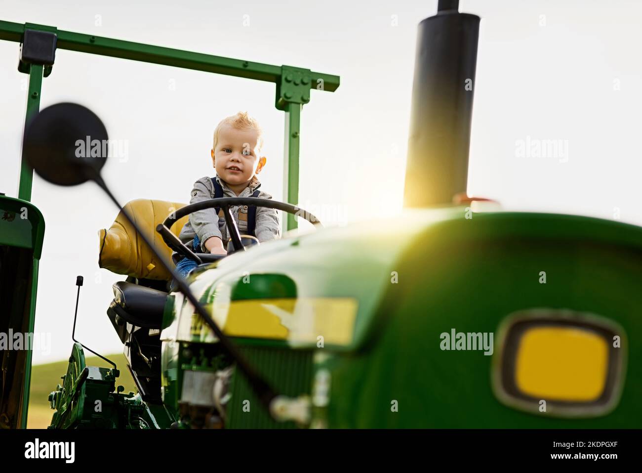 Trading modern toys for tractors. an adorable little boy riding a ...