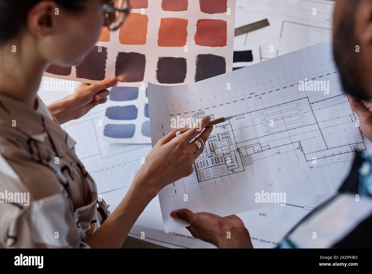 Close up of two architects discussing floor plans and color swatches ...