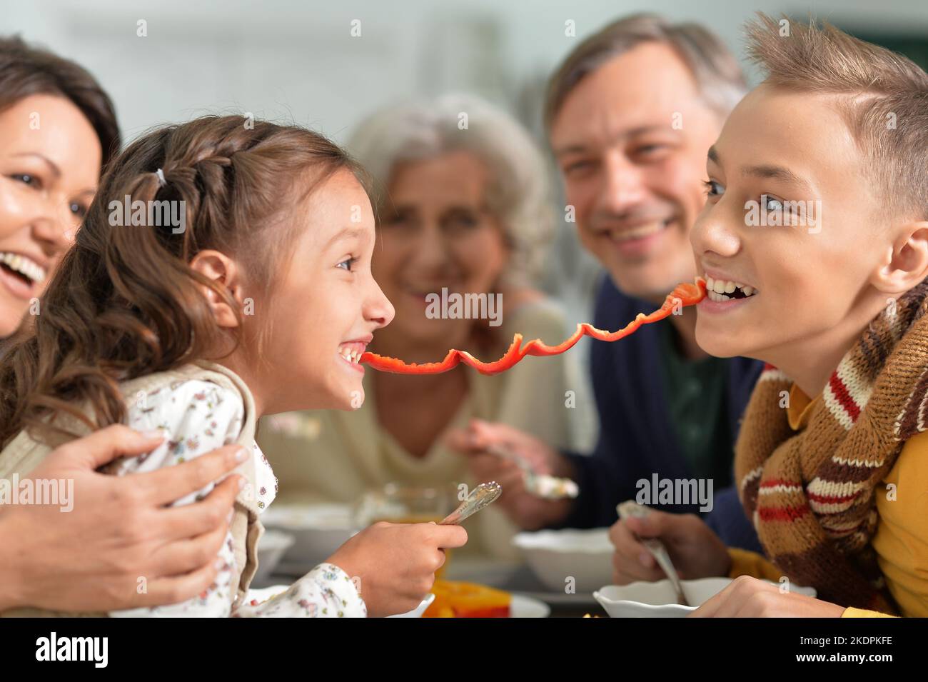 Happy family of different generations eating together Stock Photo - Alamy