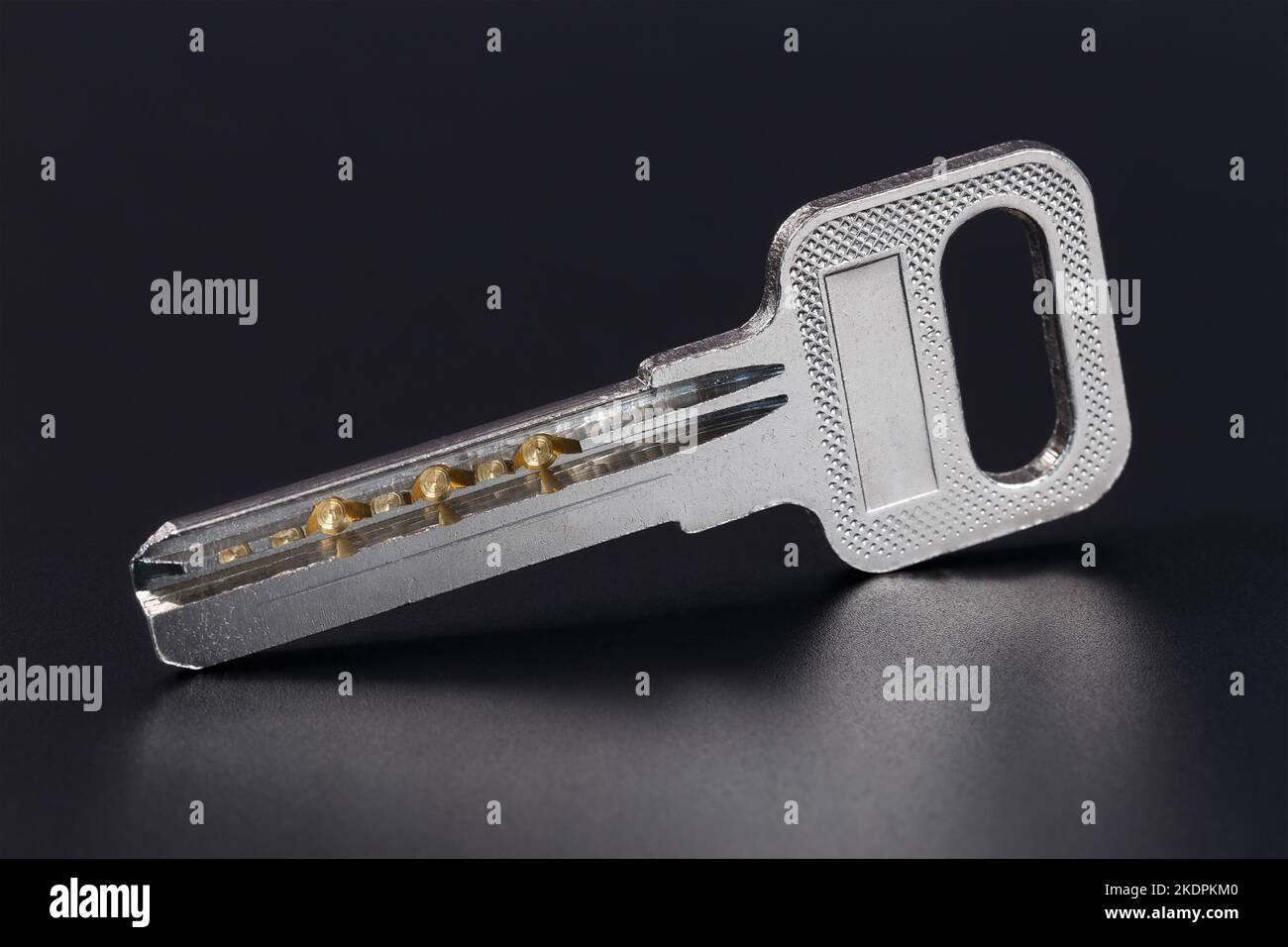 Flat perforated key close-up on a dark background with backlight Stock ...
