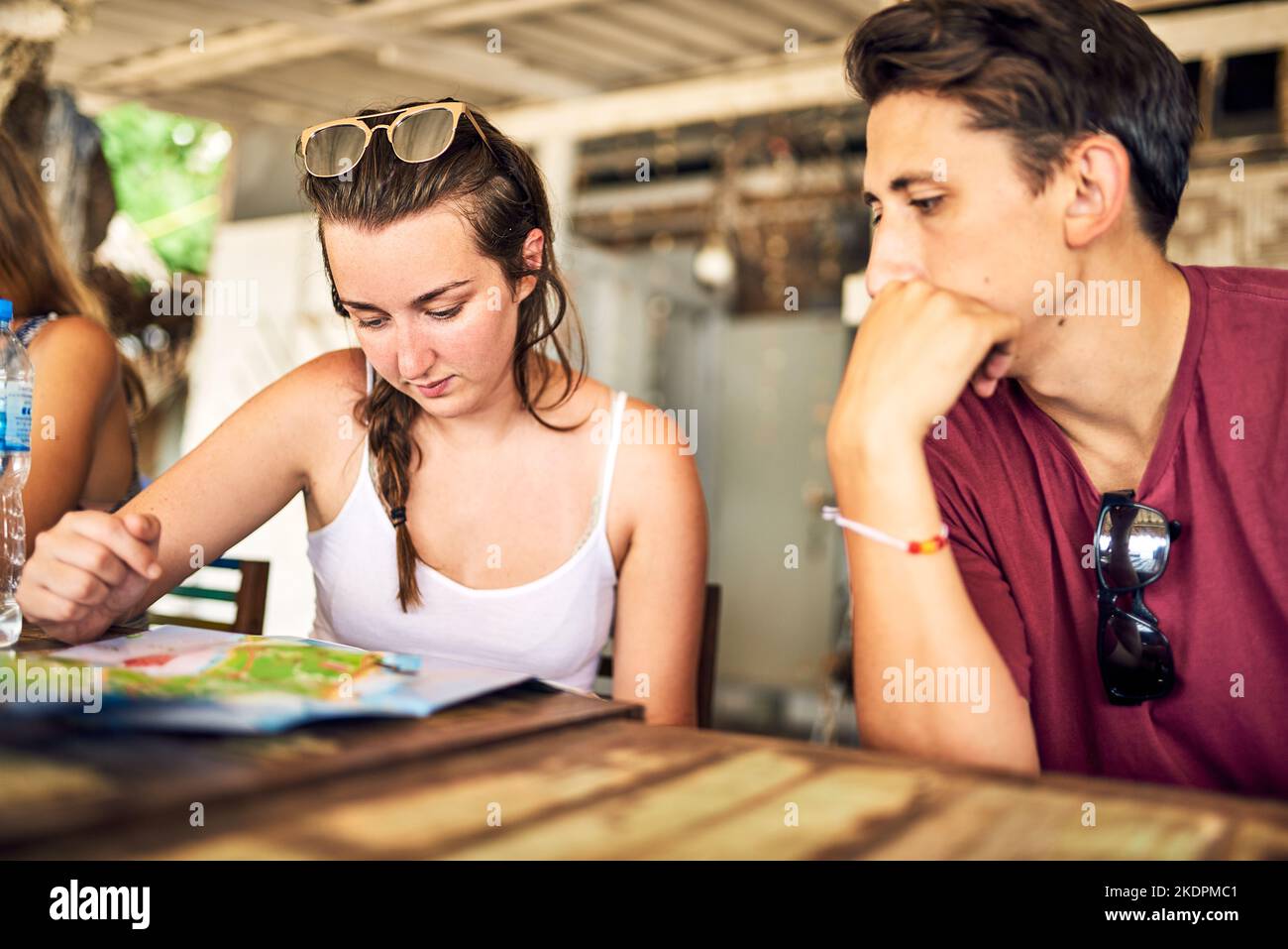 What are you thinking of having. two young friends looking at a menu ...
