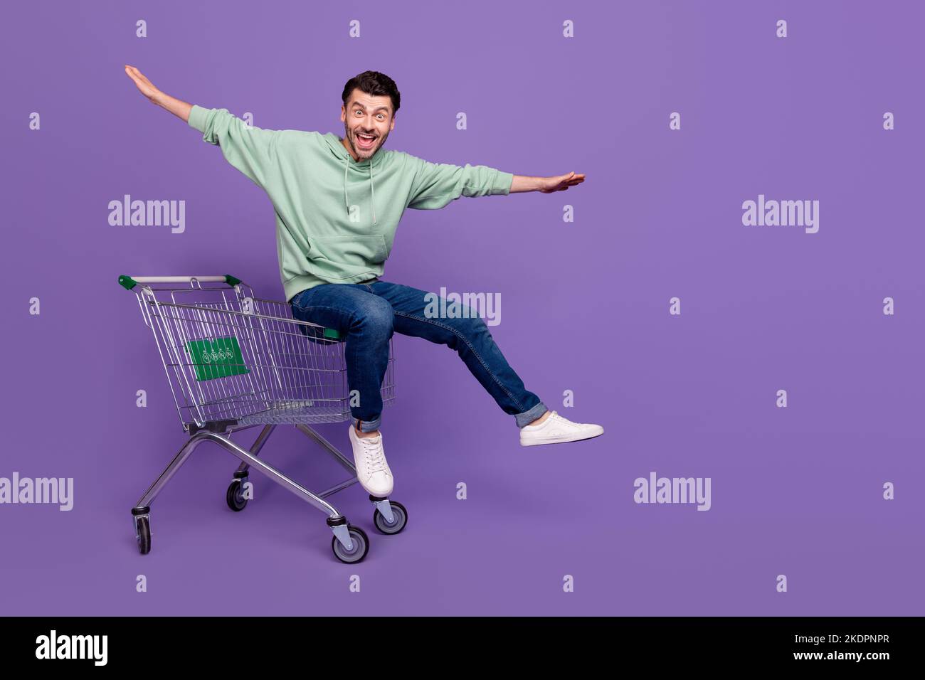 Full size portrait of positive crazy person sit market trolley arms ...