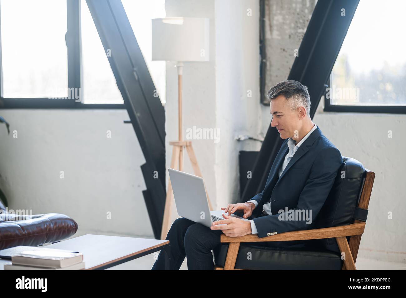 Elegant good-looking man in a suit working in the office Stock Photo ...