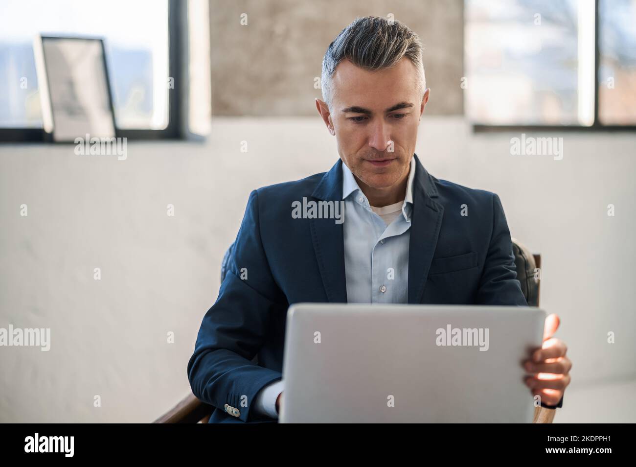 Elegant good-looking man in a suit working in the office Stock Photo ...