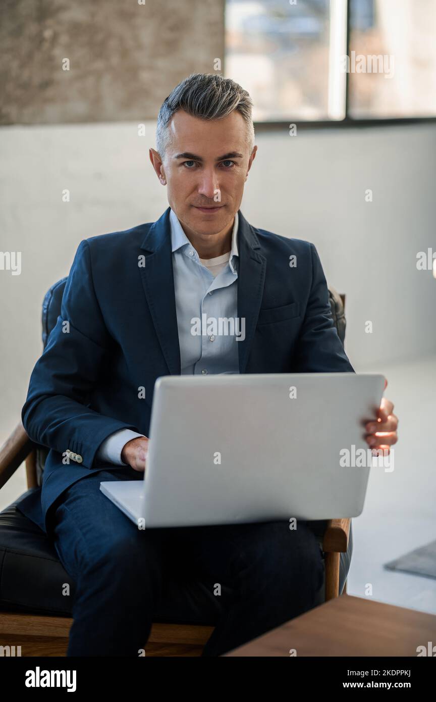 Elegant good-looking man in a suit working in the office Stock Photo ...