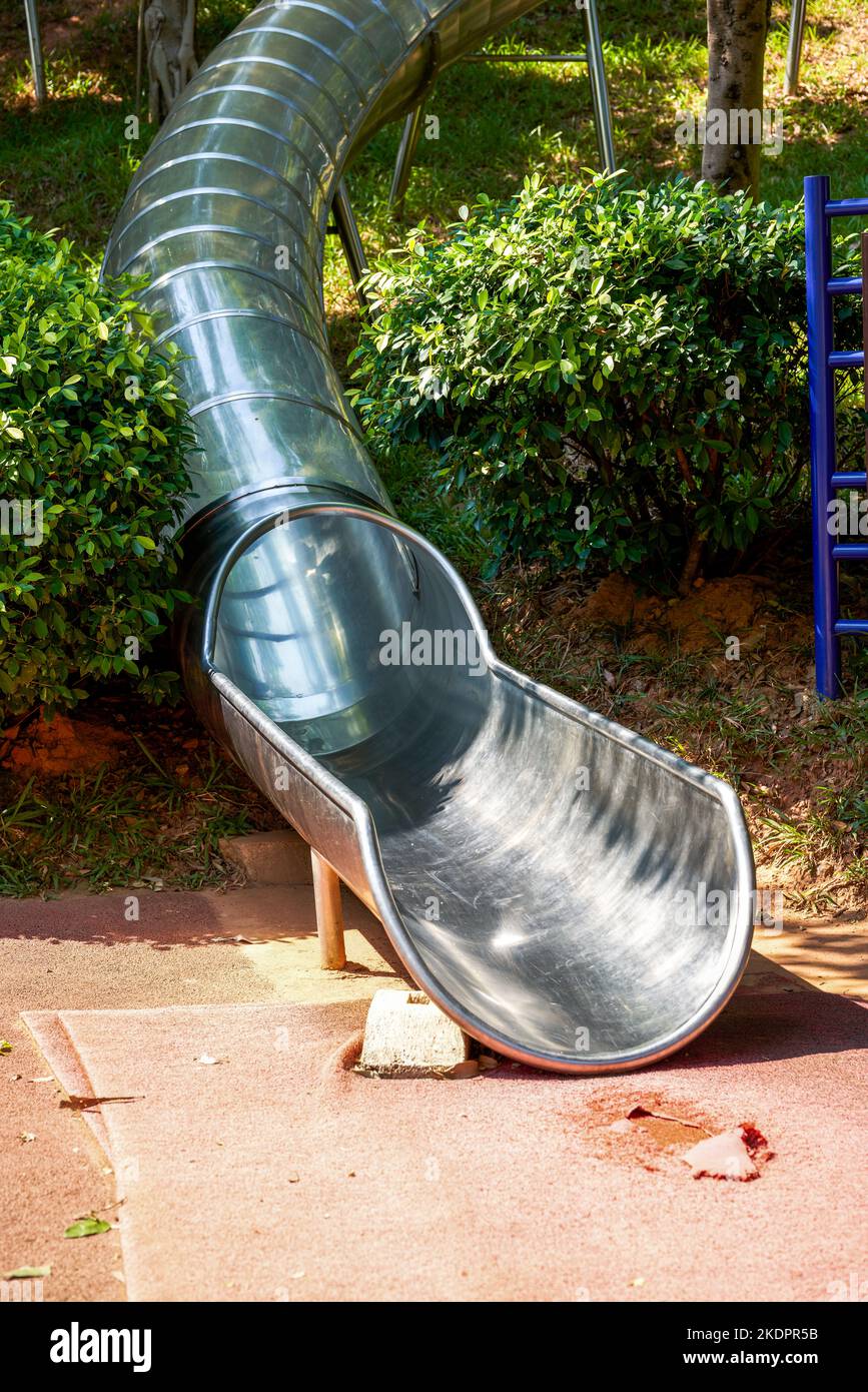 Stainless steel cylinder slide in the park playground Stock Photo - Alamy