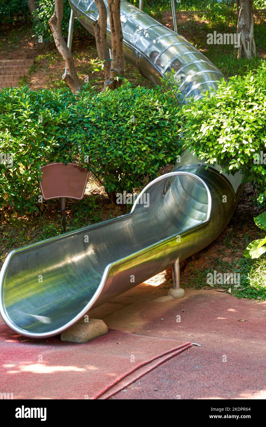 Stainless steel cylinder slide in the park playground Stock Photo - Alamy