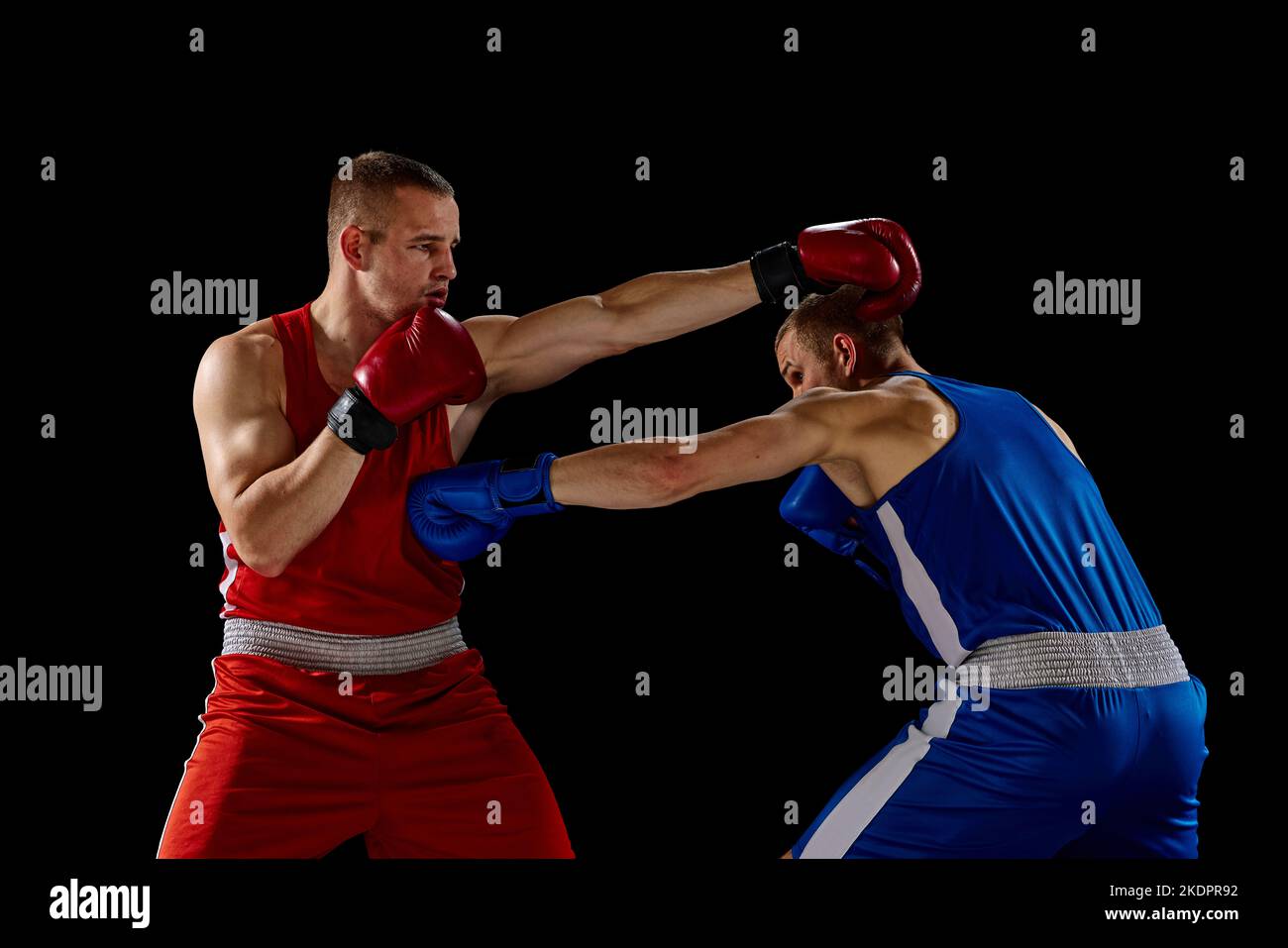 Male professional boxers in blue and red sports uniform practicing ...