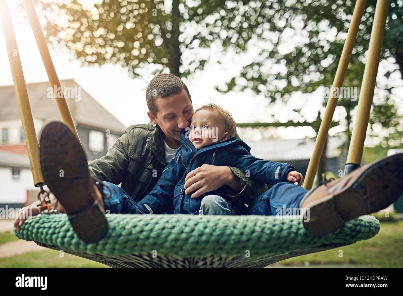 Swinging in to a leisurely weekend together. a father sitting with his ...