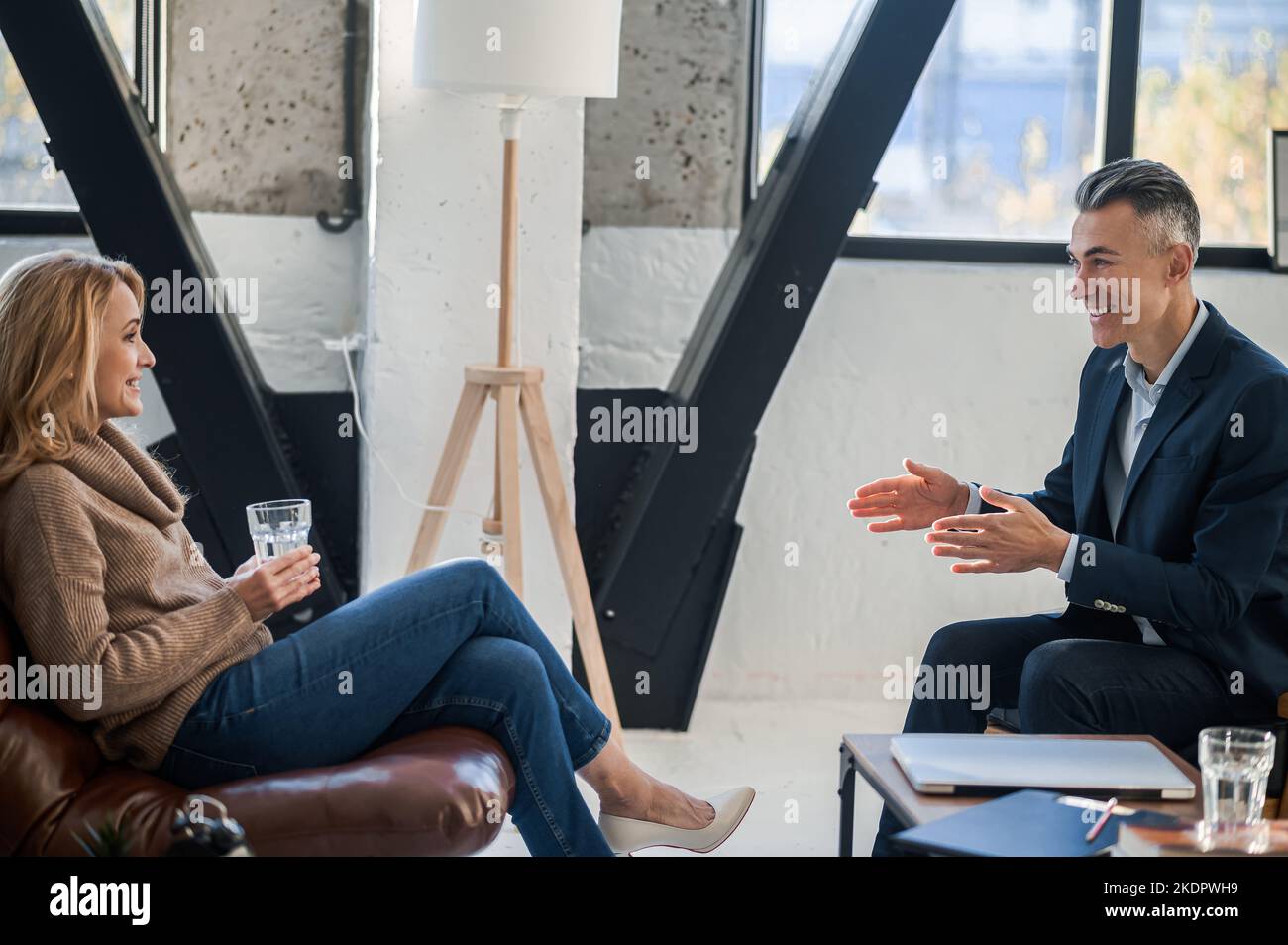Man ad woman sitting and discussing something Stock Photo - Alamy