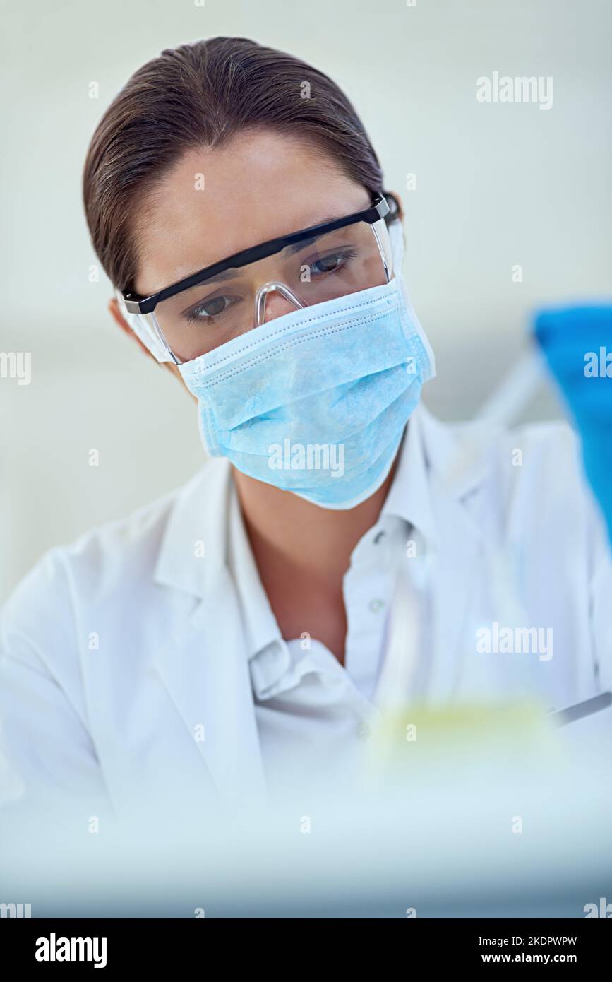 The answers lie within the details. a female scientist working alone in ...