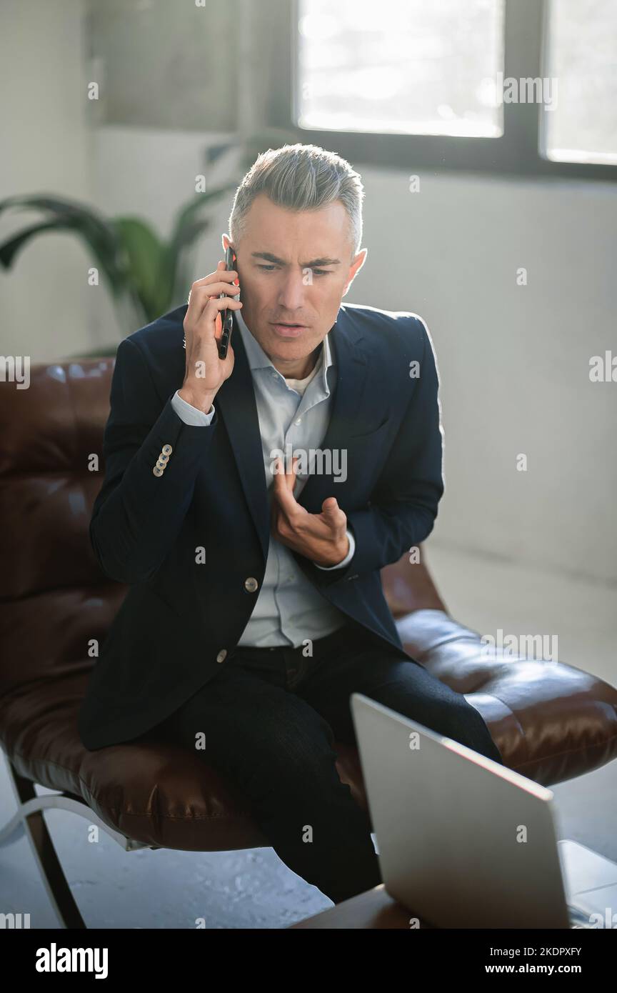 Businessman in the office talking on the phone and looking angry Stock ...