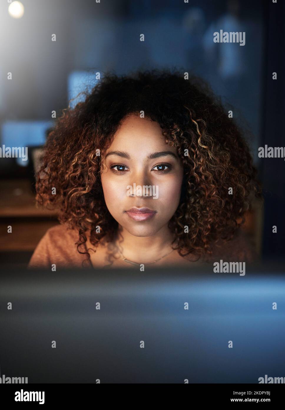 Completely focused on her task. a young woman working late in an empty ...