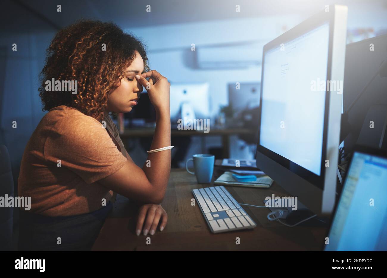 I cant do this all by myself. a young woman working late in an empty ...