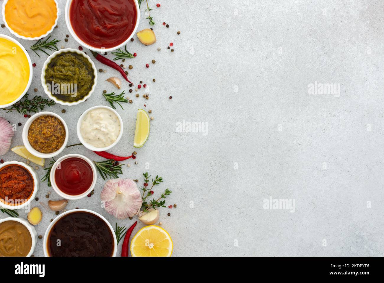 Different types of sauces in bowls with seasonings, rosemary and pepper ...