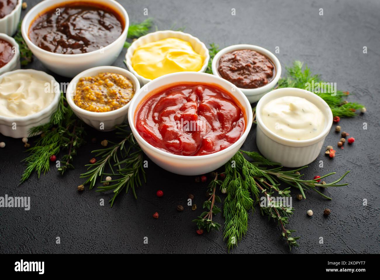 Different types of sauces in bowls with seasonings, rosemary and dill ...
