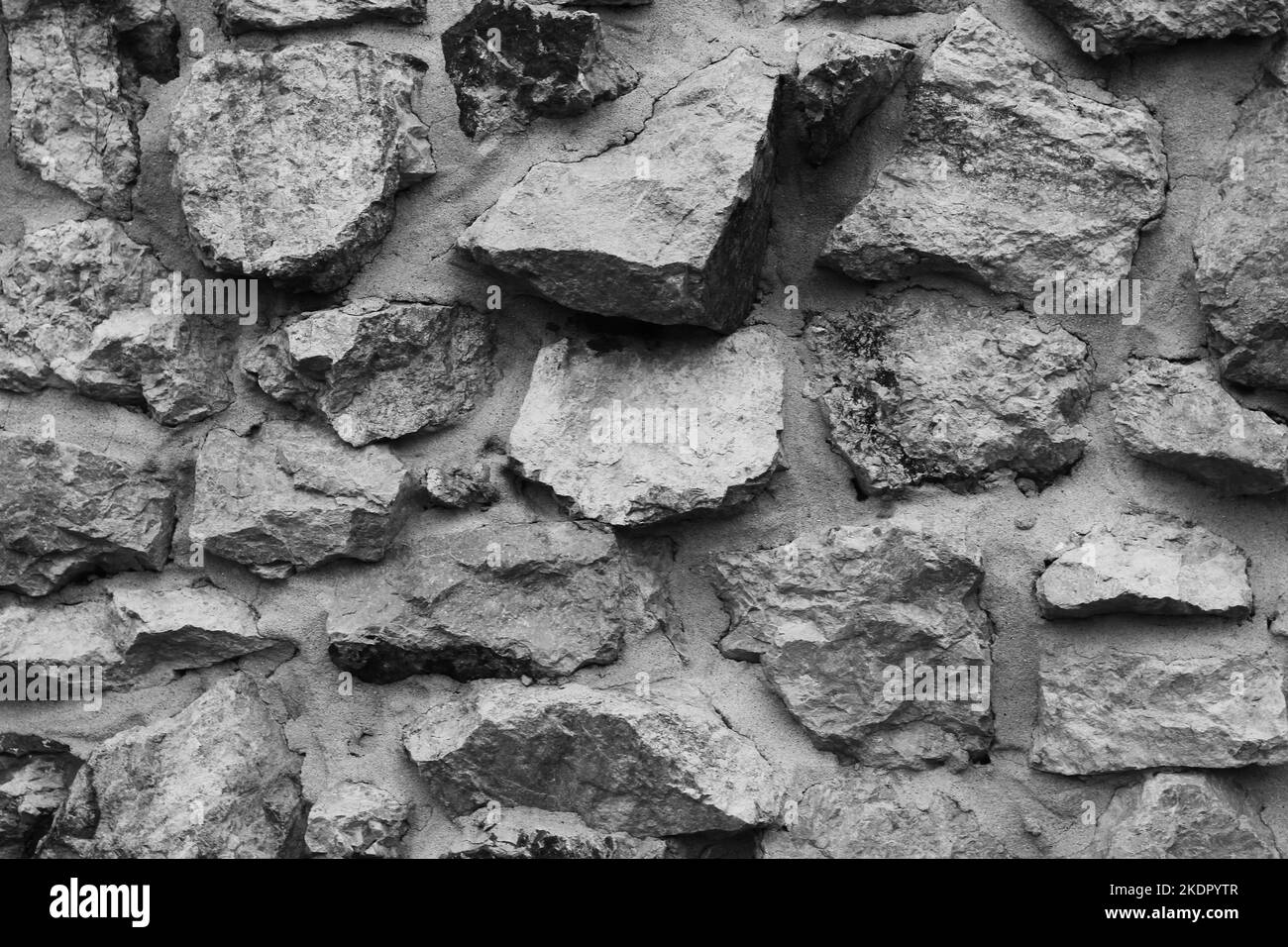 Worn and weathered natural stone and boulder wall built in a random ...