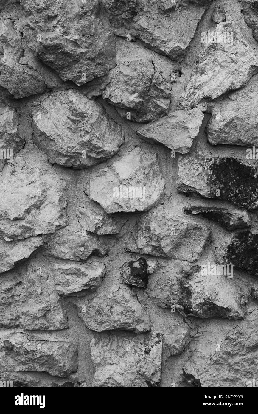 Worn and weathered natural stone and boulder wall built in a random ...