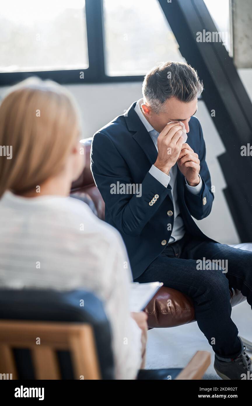 Mid aged man looking upset and telling about his problems to a ...