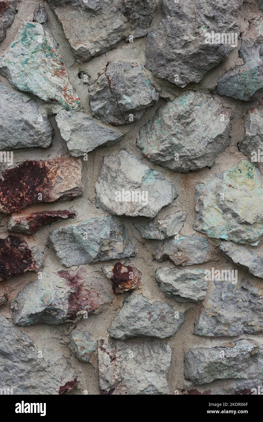 Worn and weathered natural stone and boulder wall built in a random ...