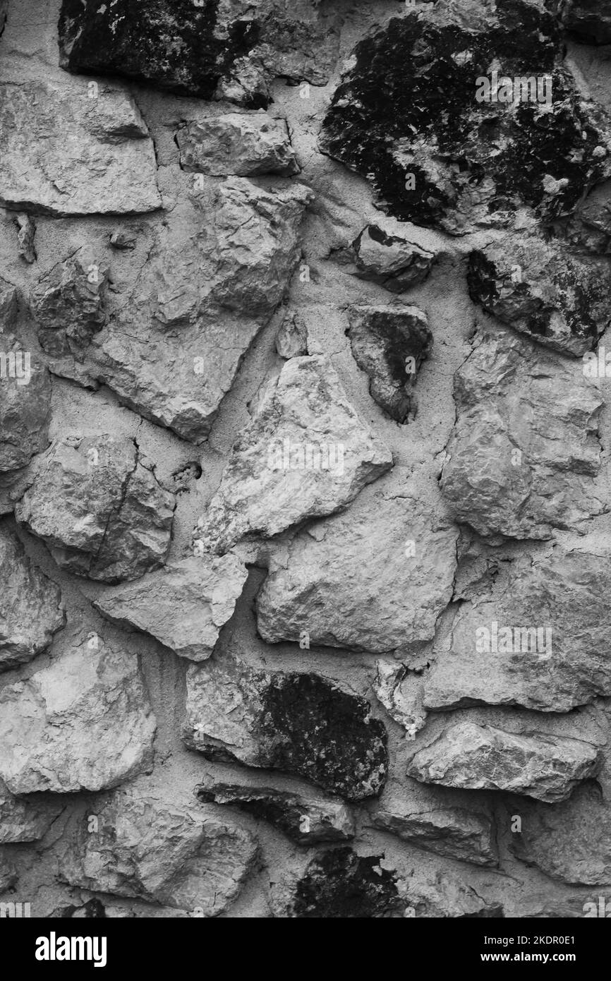 Worn and weathered natural stone and boulder wall built in a random ...
