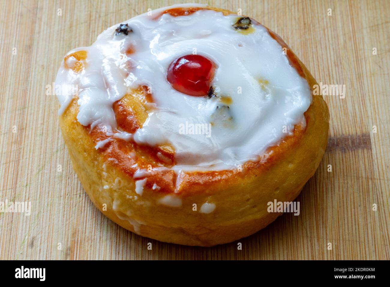 Belgian bun, smothered in icing and topped with a cherry Stock Photo ...