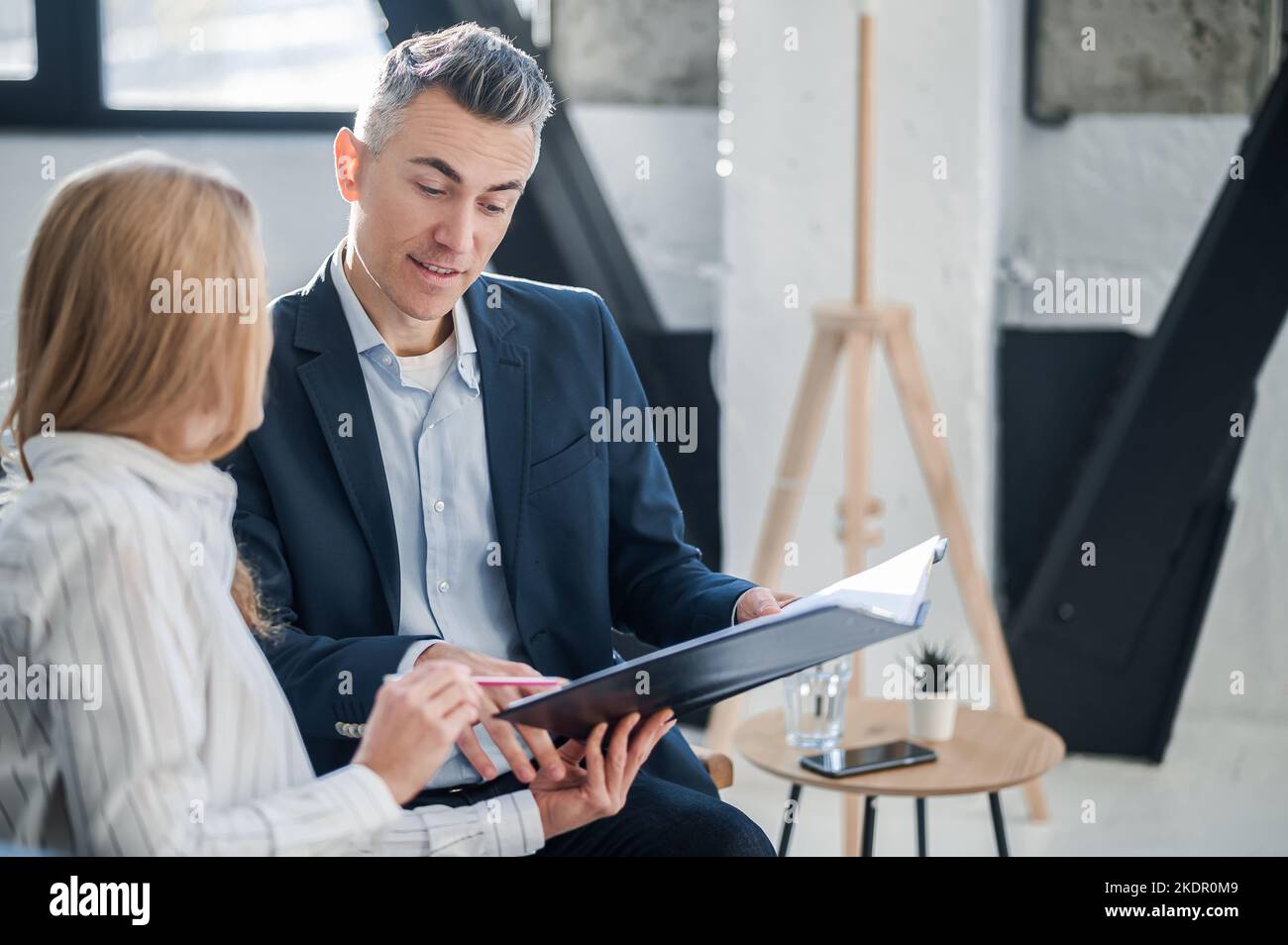 A man and a woman working together in the office and looking involved ...