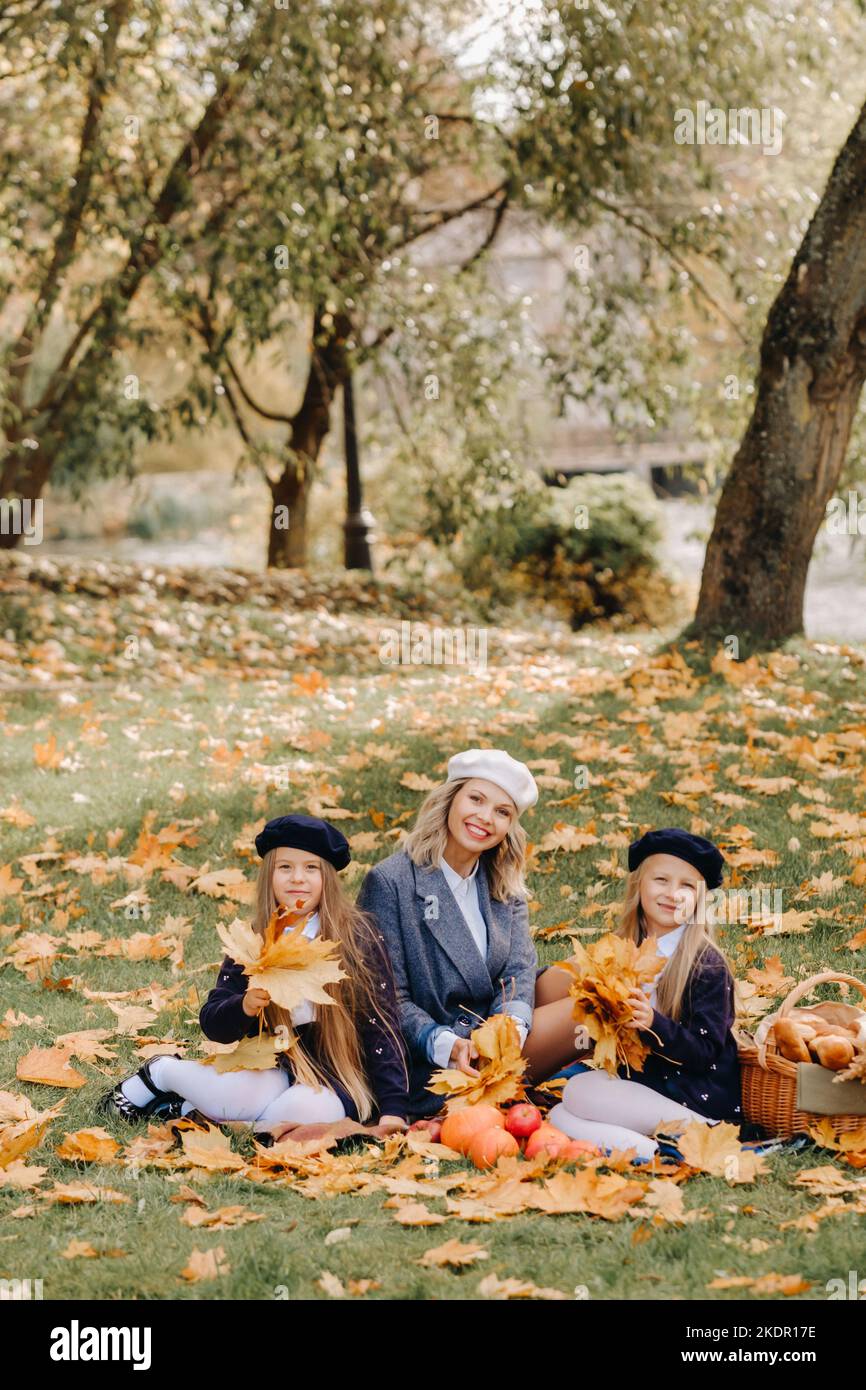 A big family on a picnic in the fall in a nature park. Happy people in ...