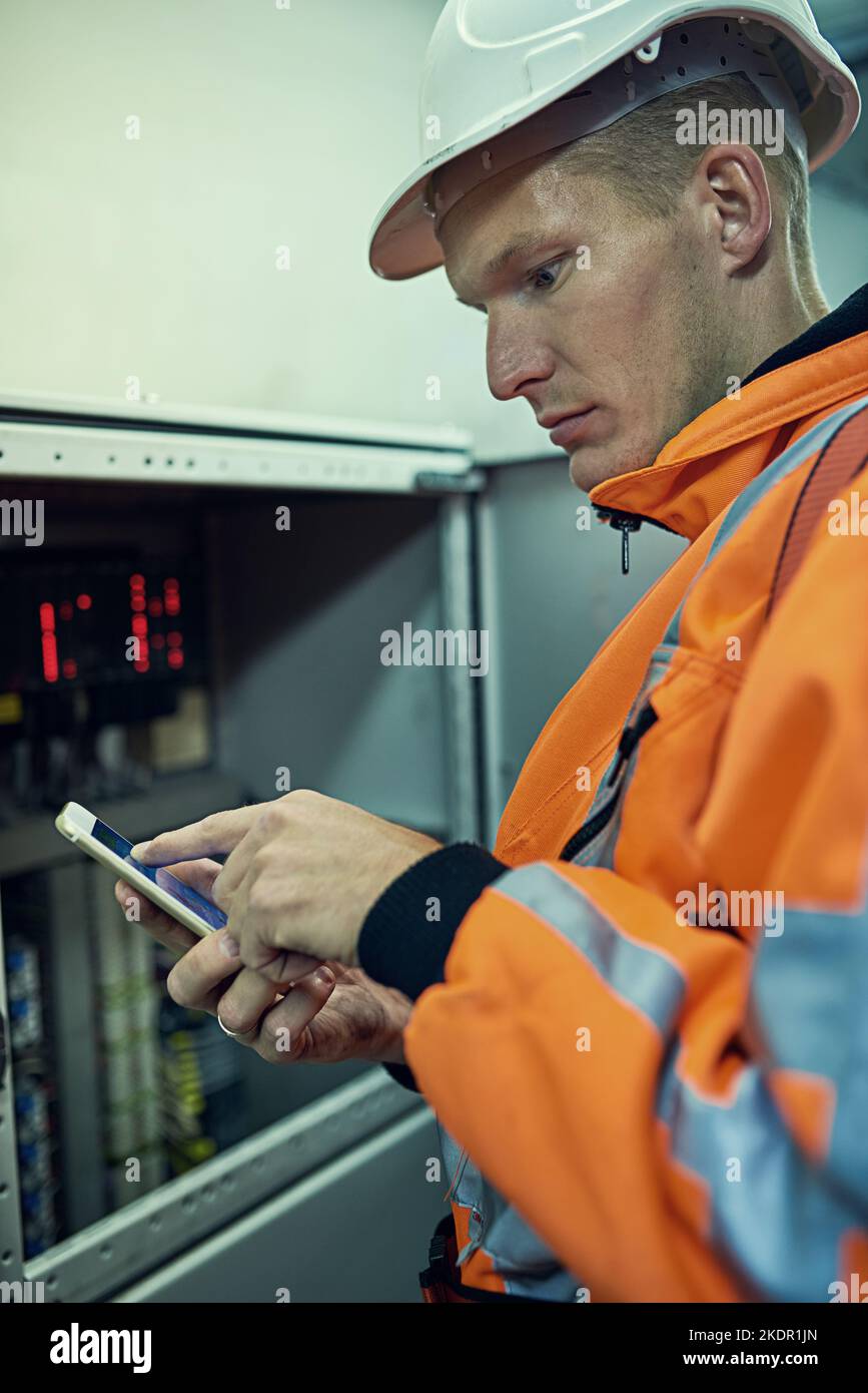 Double checking his checklist. a young engineer working with ...