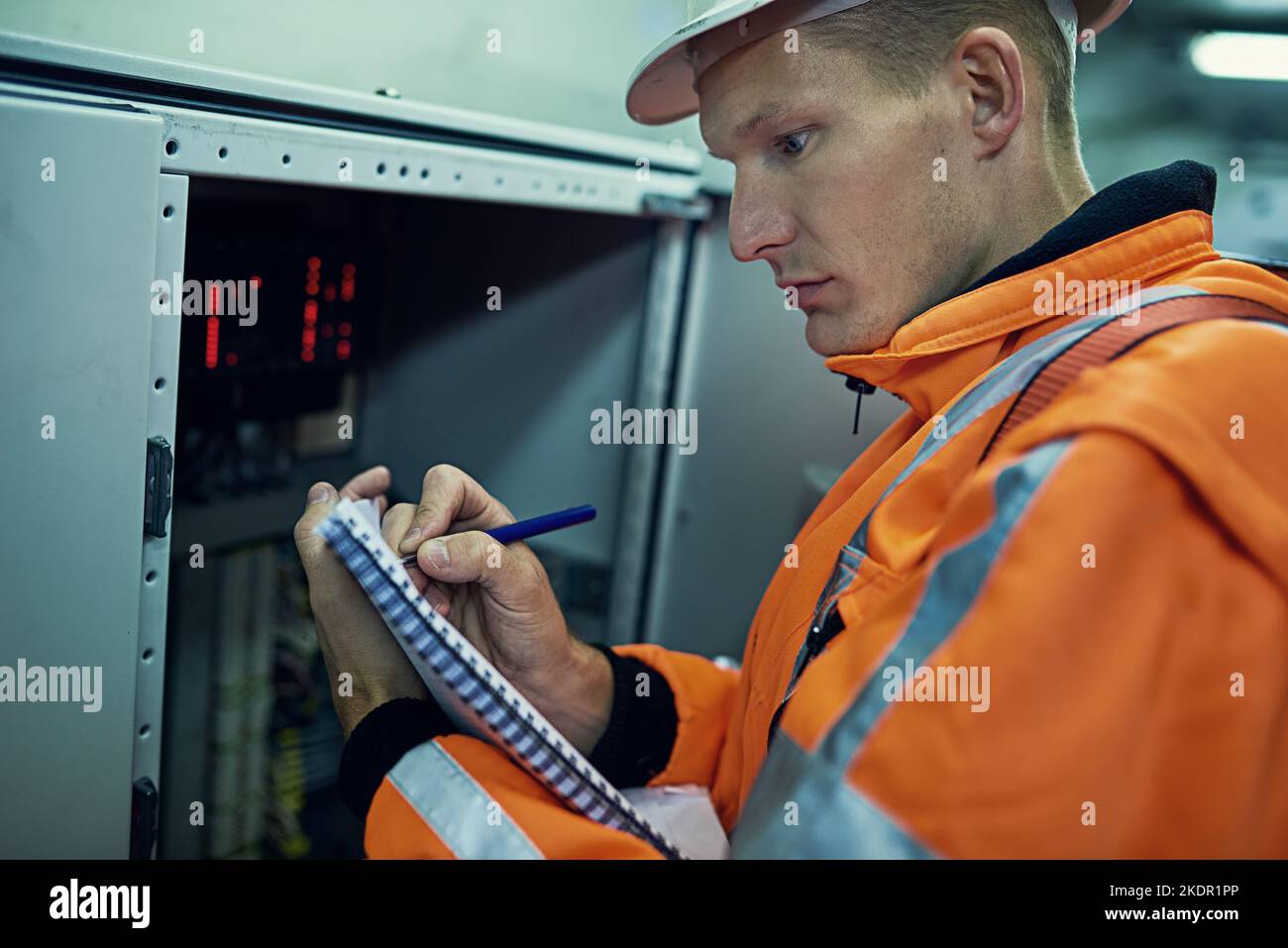 Making a note of the days results. a young engineer working with ...