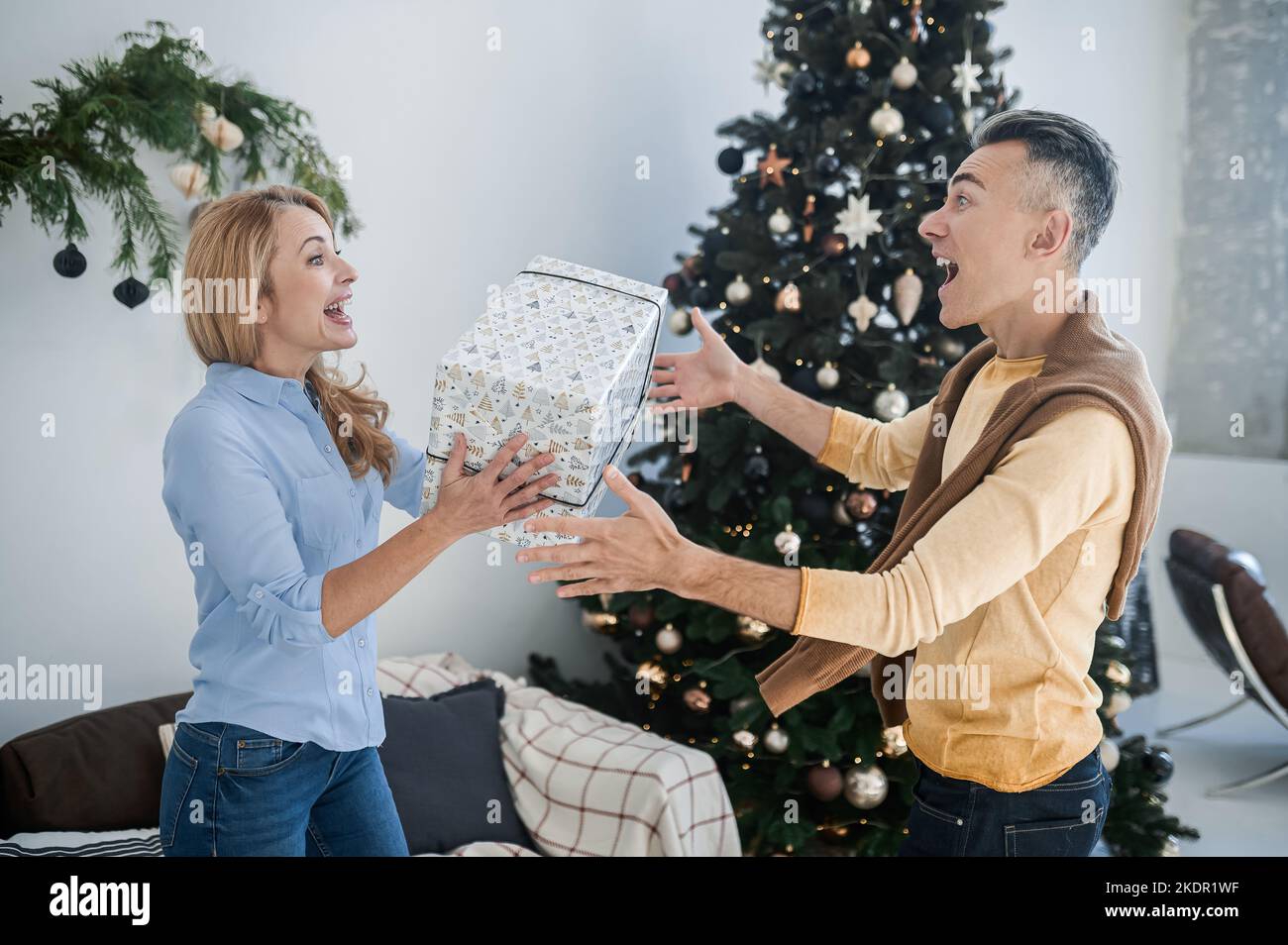Two happy people exchanging xmas gifts Stock Photo - Alamy