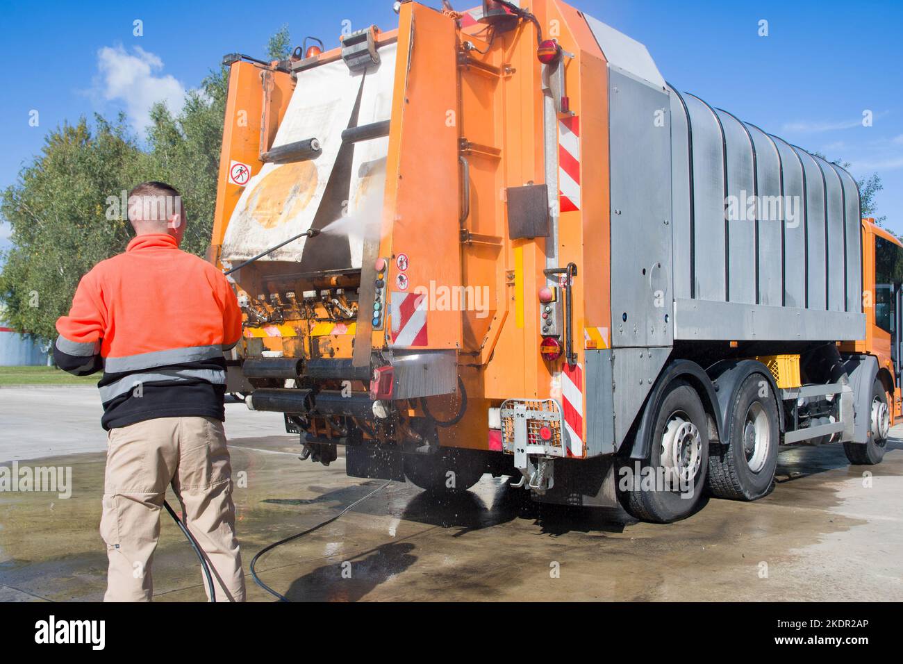 garbage truck Operator Pressure Washing Can After Waste Collection ...