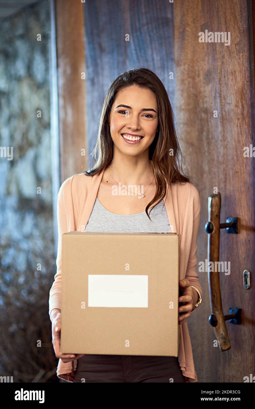 Heres to a new start. Portrait of a smiling young woman carrying a box ...