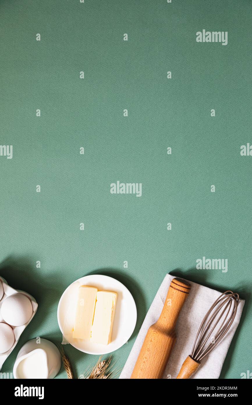 Frame of food ingredients for baking on a green pastel background ...