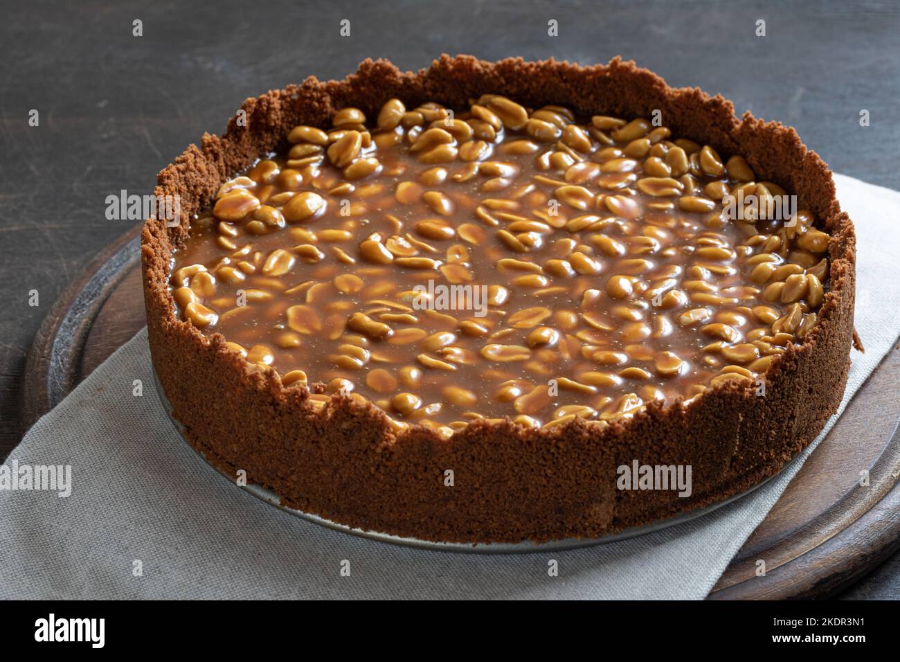 Homemade caramel-peanut cheesecake on a dark background. Morning ...