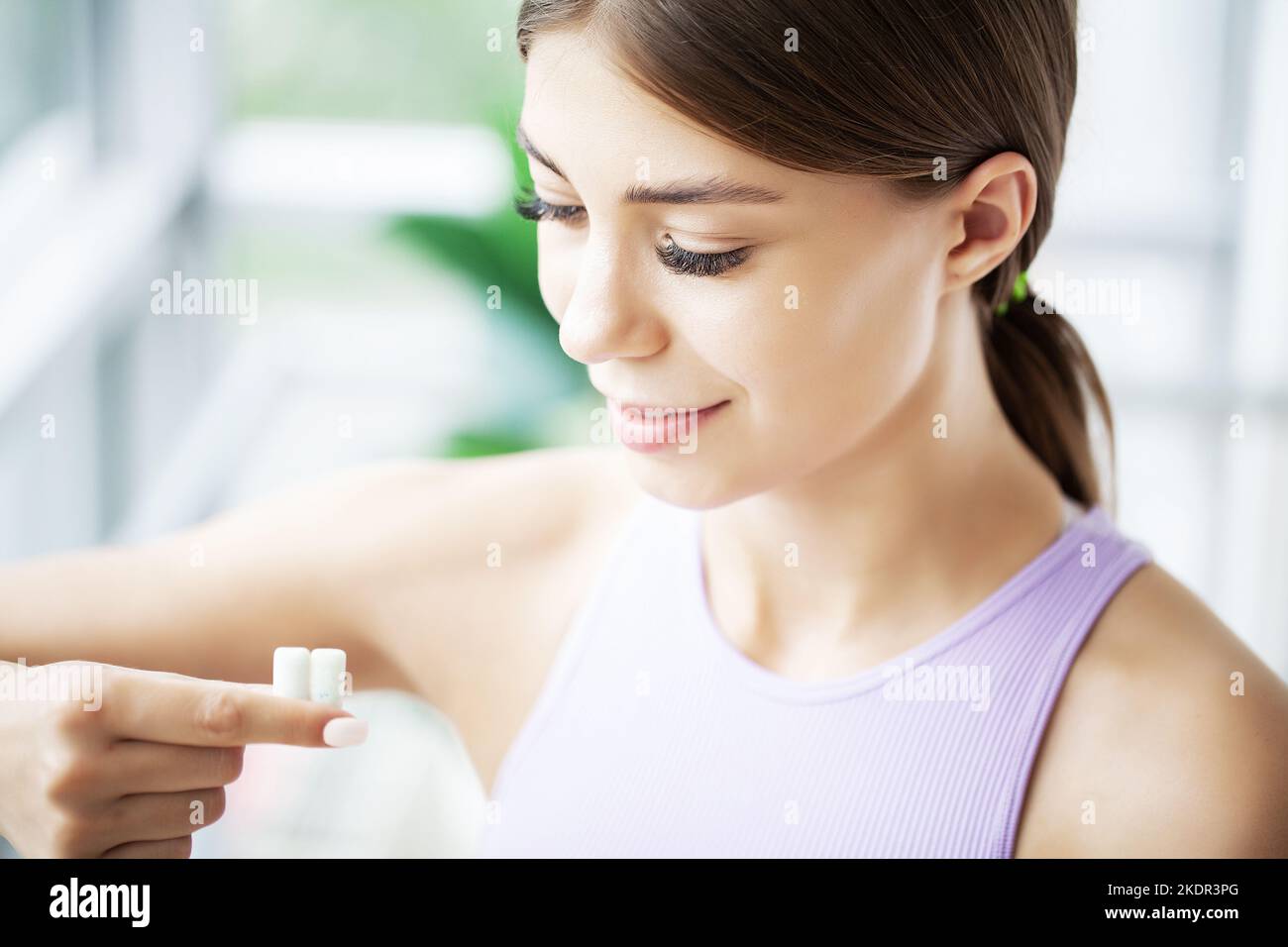Beautiful young woman eating chewing gum, smiling Stock Photo - Alamy