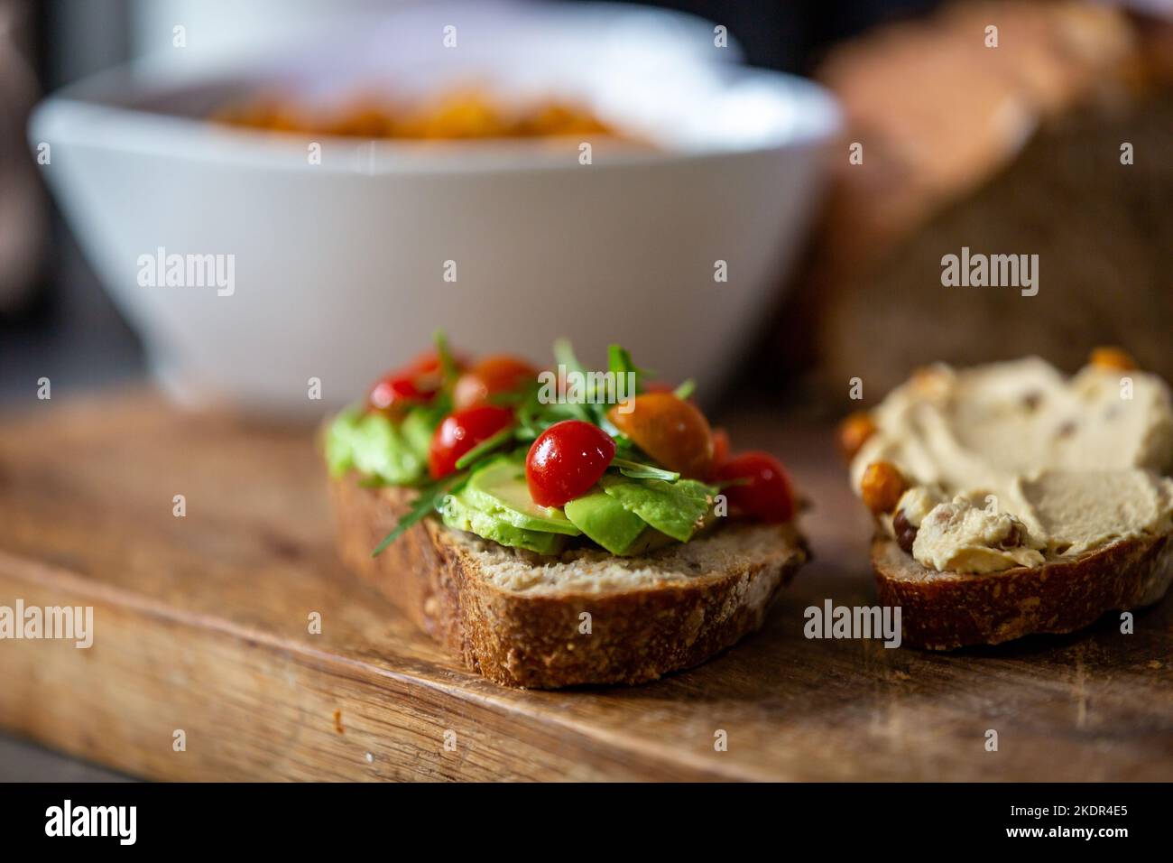 A close up of healthy rocket, avocado, hummus and tomato on sourdough ...