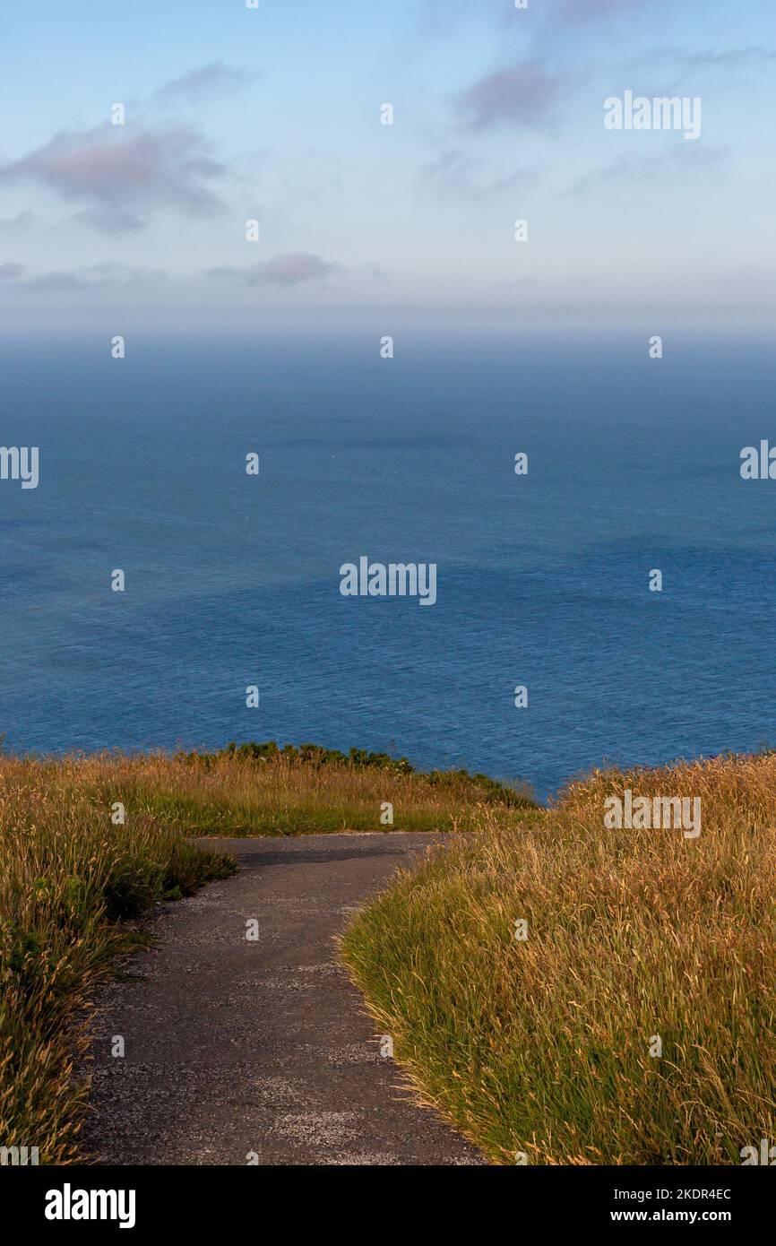 A pathway leading down a hill, with a view of the sea Stock Photo - Alamy