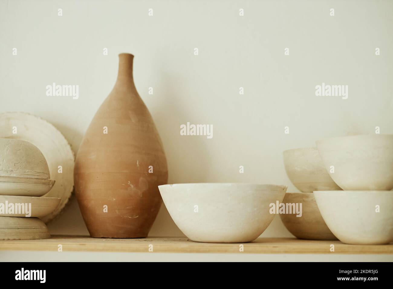 Minimal background image of raw handmade ceramics on shelf in pottery ...