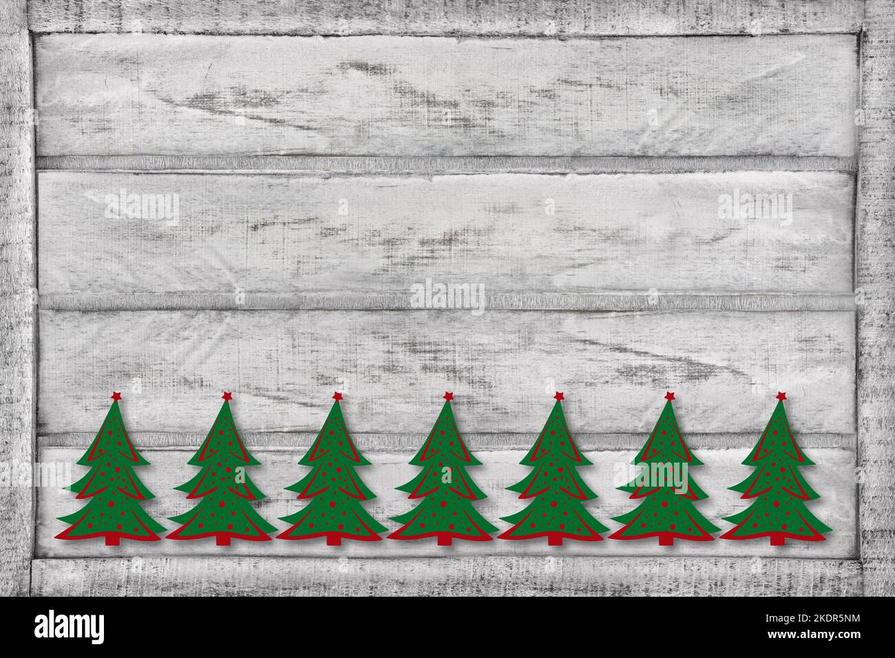 Seven Christmas trees on wooden background Stock Photo - Alamy