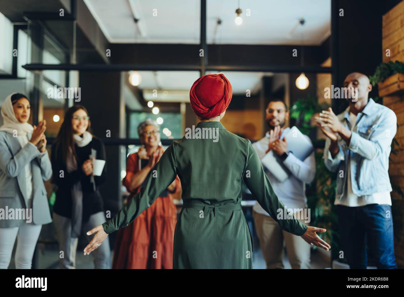 Muslim businesswoman receiving an applause from her colleagues during a ...