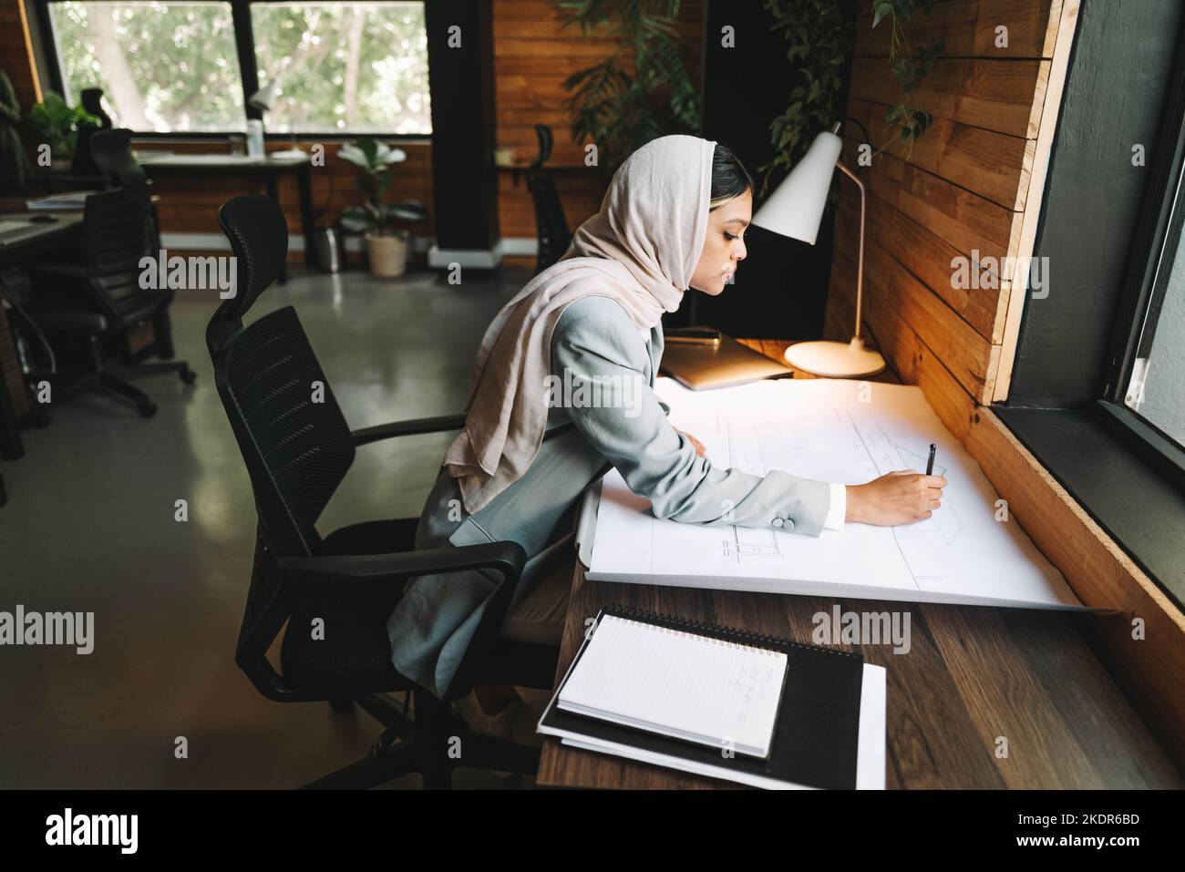 Creative Muslim designer working with architectural drawings in a ...