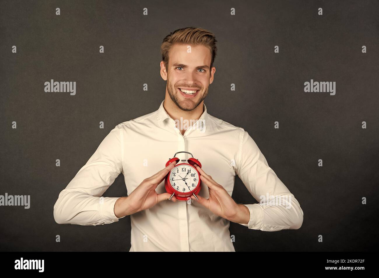 Happy employee holding alarm timepiece dark background, clock Stock ...