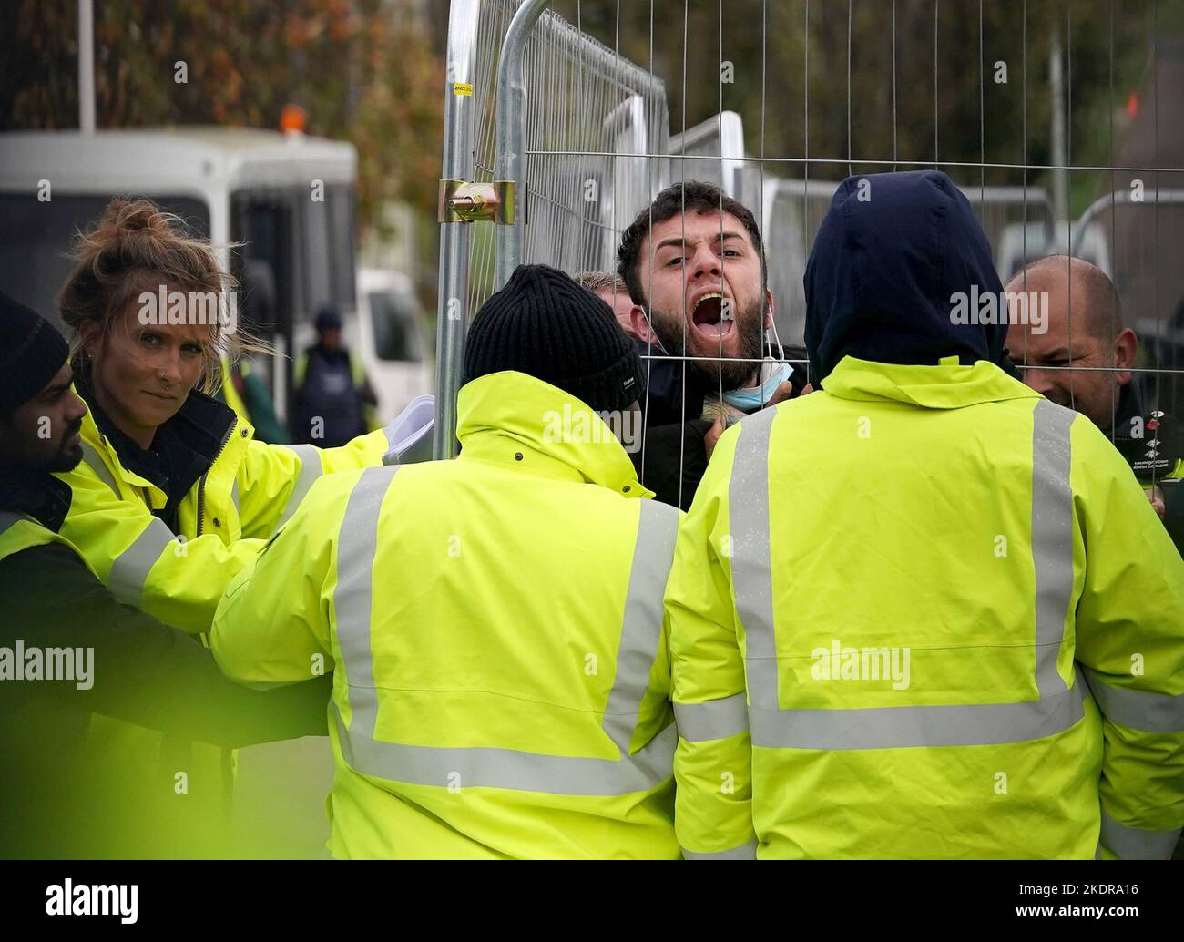 A migrant attempting to communicate with journalists is pinned against ...