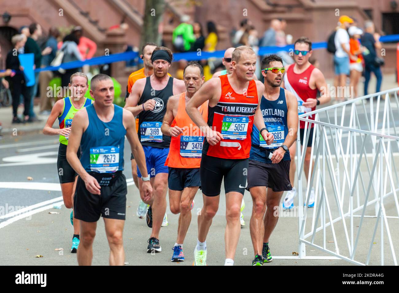 Runners pass through Harlem in New York near the 22 mile mark near ...