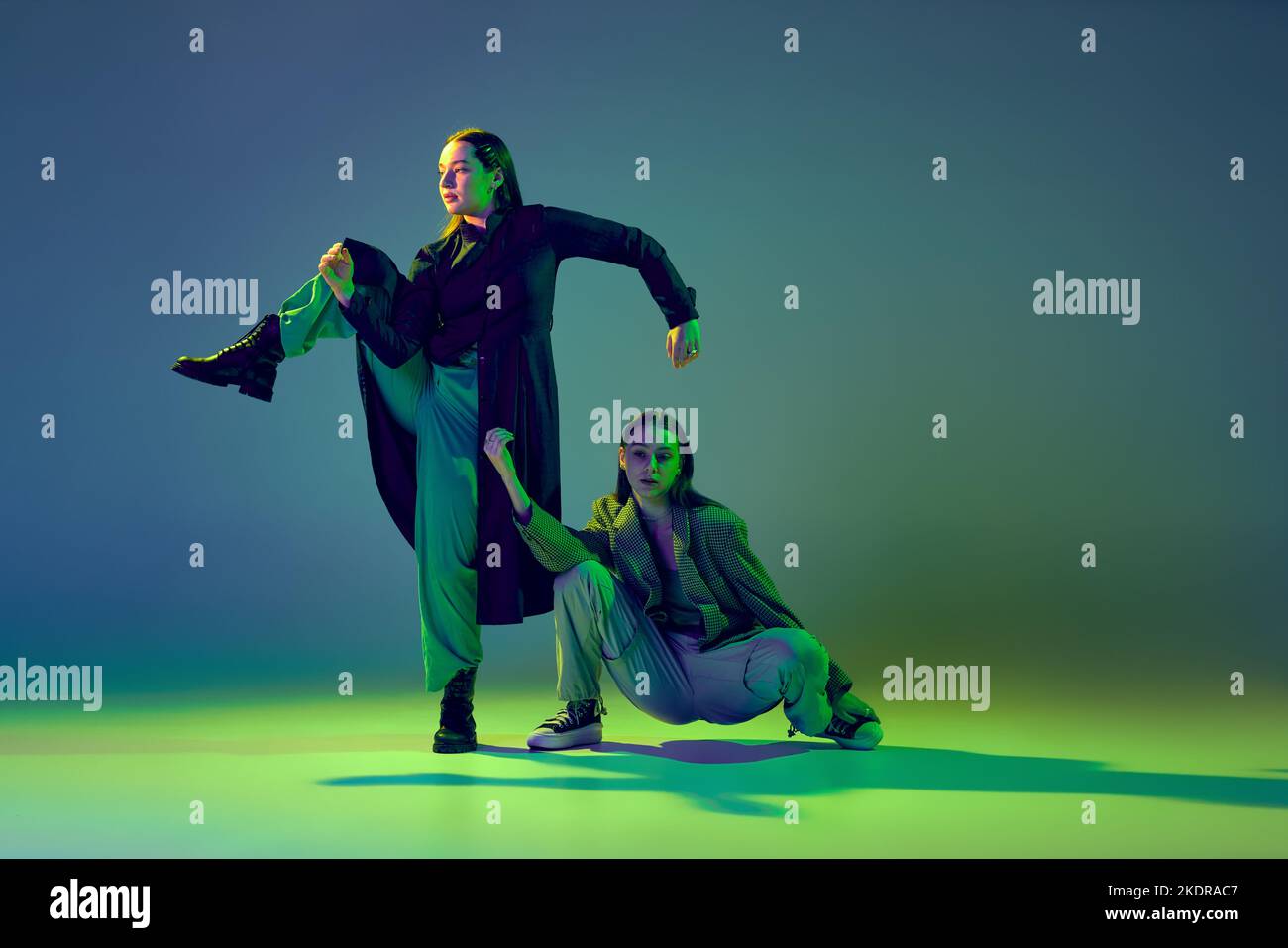 Stylish young girls in casual clothes dancing experimental style dance ...