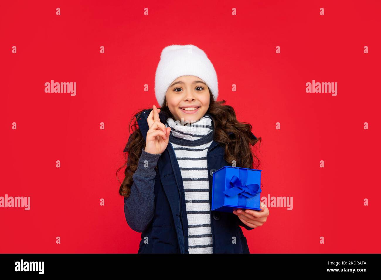 happy child in puffer jacket and hat hold box. kid with present. teen ...